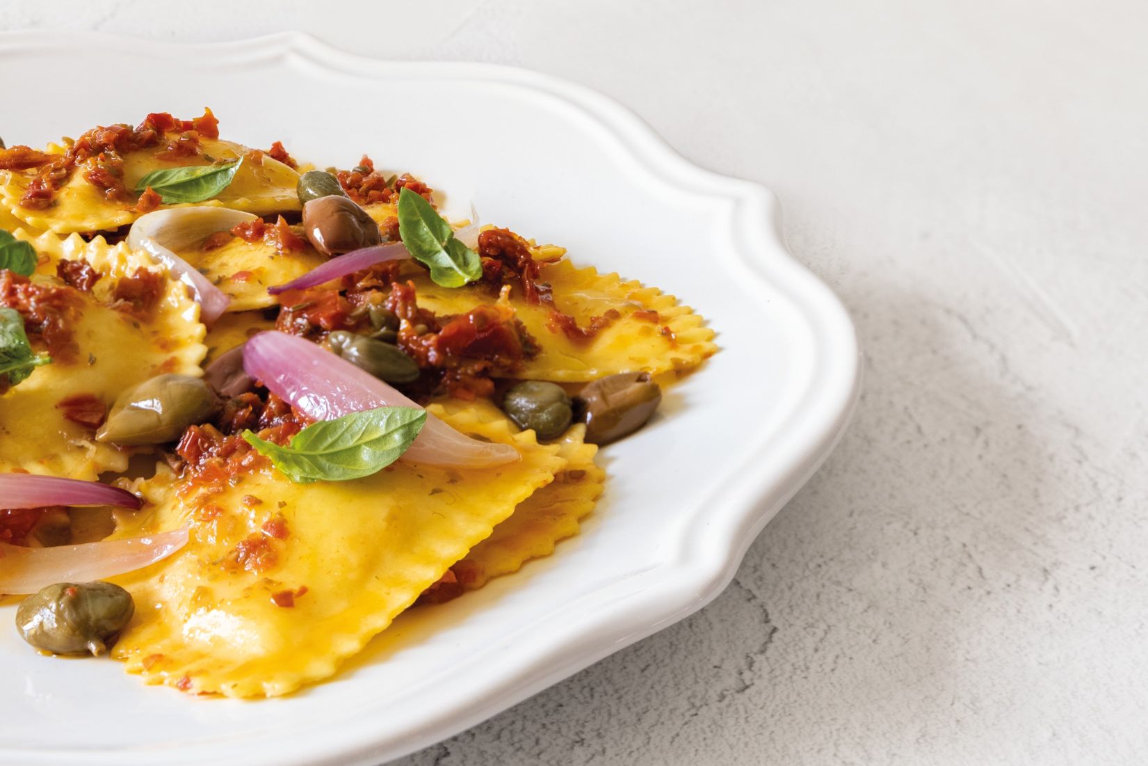 Mezzelune al salmone con olive, capperi e pomodori secchi | Conad